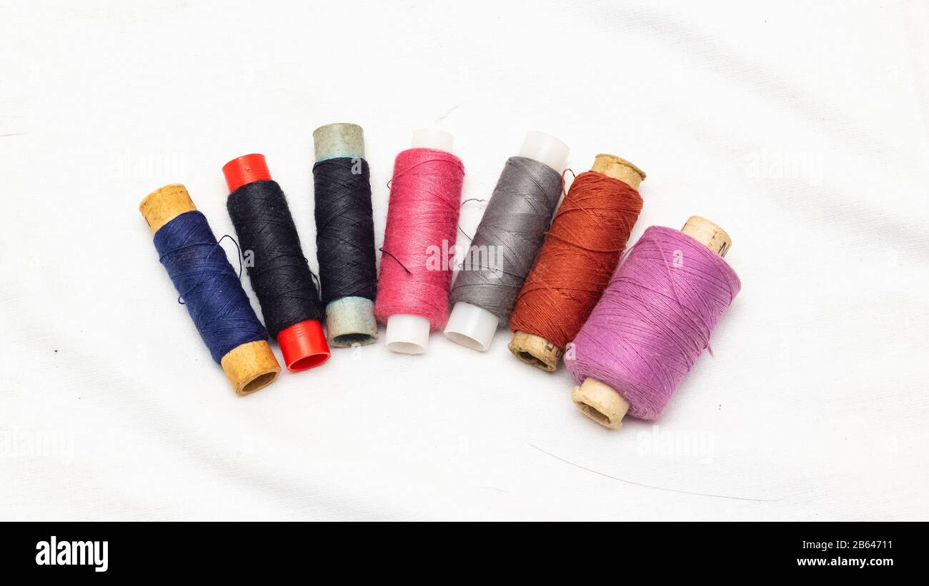 Multi-colored spools of thread on white background Stock Photo - Alamy