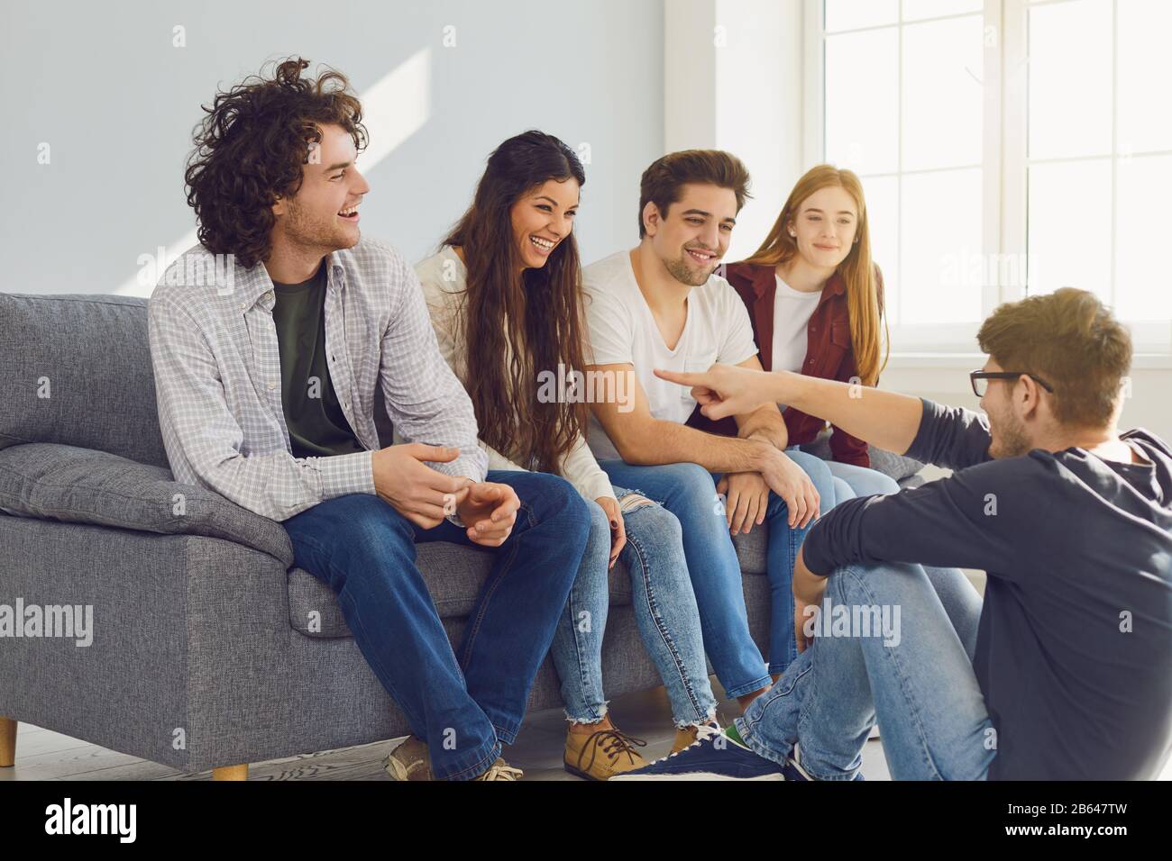 A group of friends talking in a room Stock Photo - Alamy