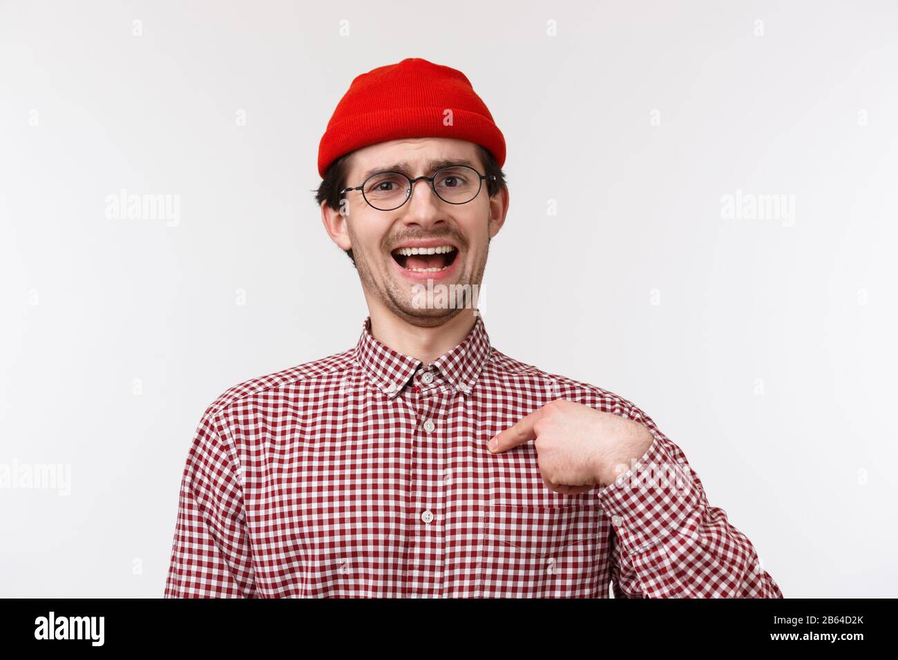 Close-up portrait boastful funny bearded young man in red beanie and ...