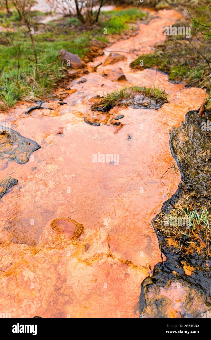 Red polluted water stream among grass Stock Photo - Alamy