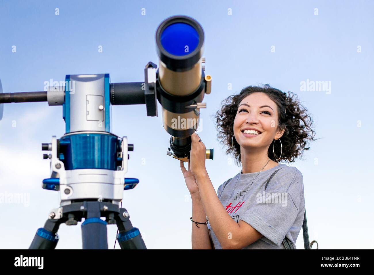 girl looking through a telescope outdoors Stock Photo - Alamy