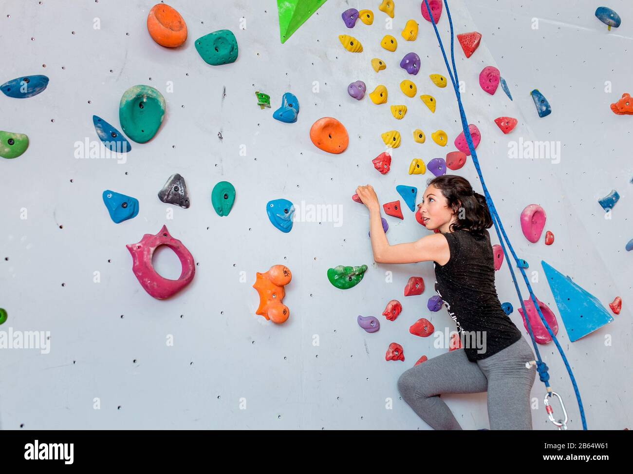 Athletic woman climbing indoors, view from the back Stock Photo - Alamy