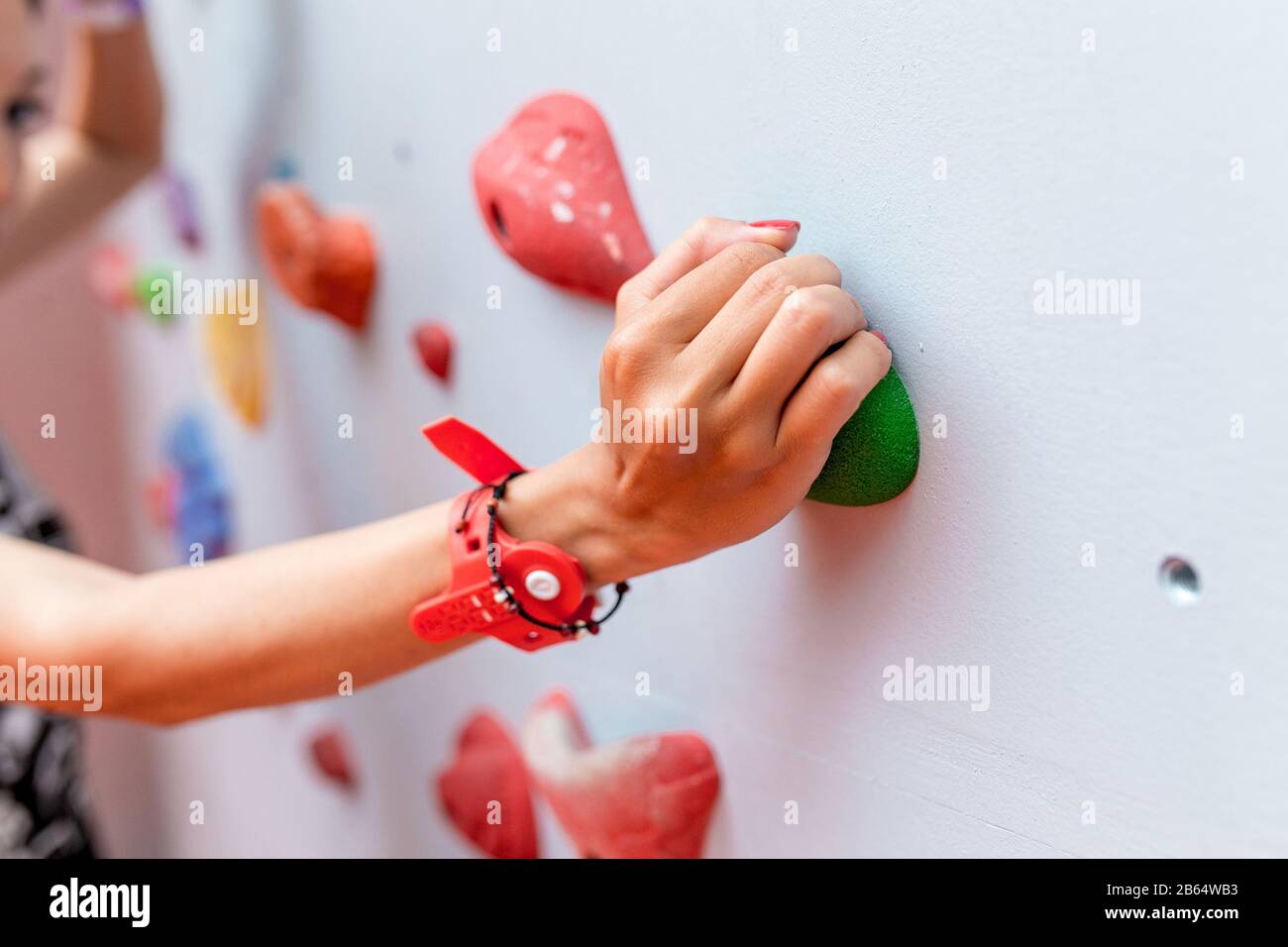 Climber hands holding artificial boulder in climbing gym, closeup shot ...