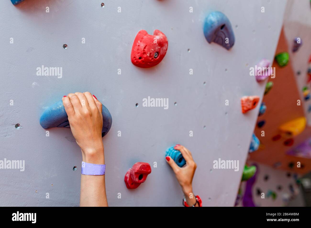 Climber young woman starting bouldering track on artificial wall indoor ...