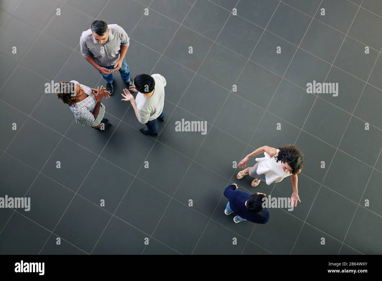 Business people talking in office hall, discussing projects and ideas ...