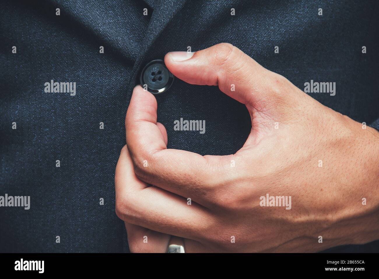man correct button on jacket, hands close-up Stock Photo - Alamy