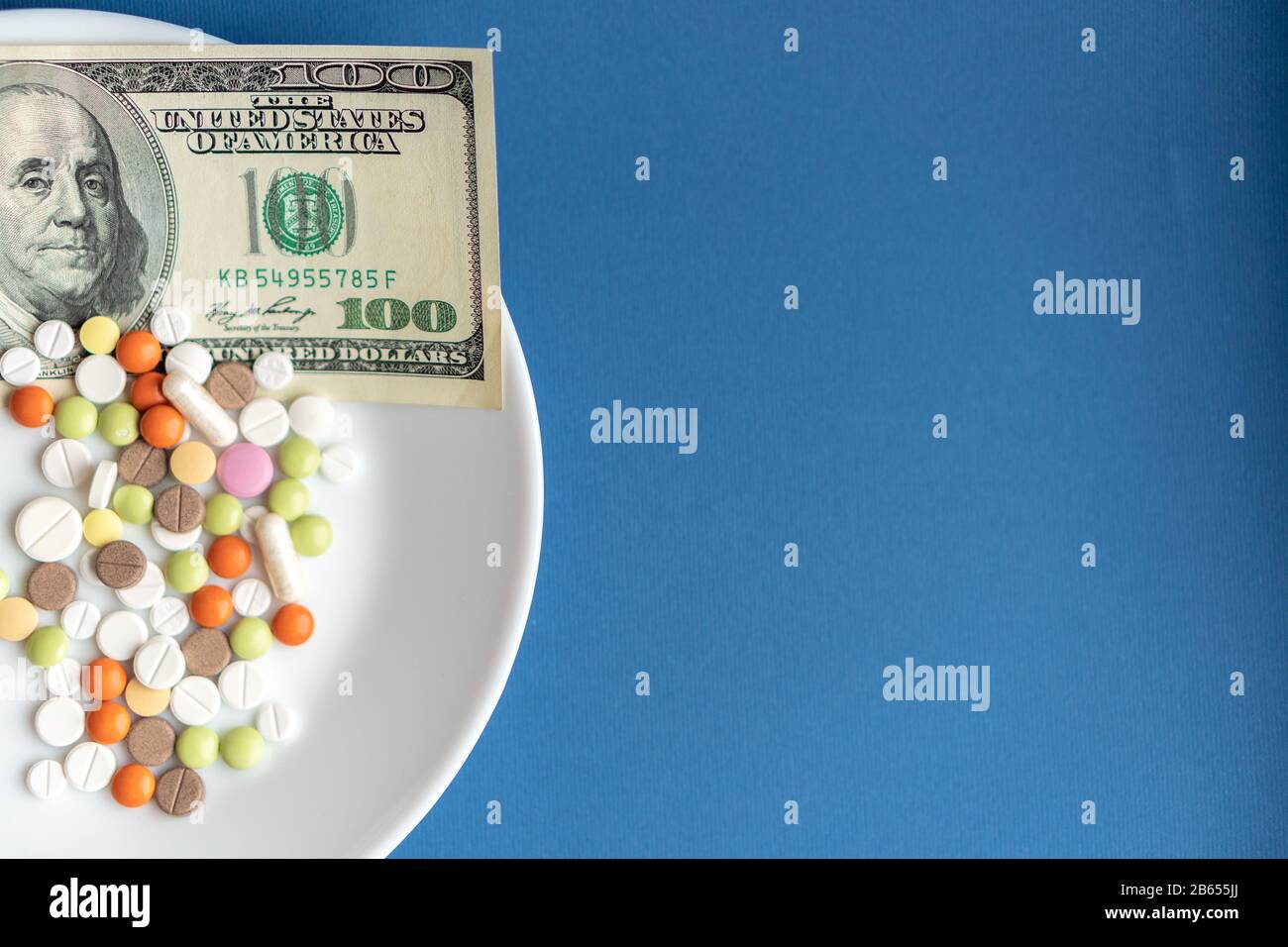 Medicines costs money. Drugs and dollars.White plate with multi-colored ...