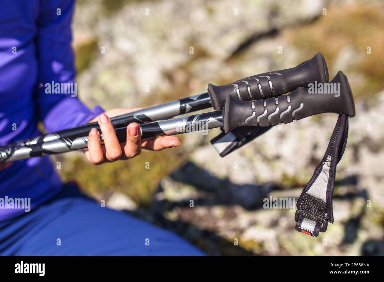 Hand holding a pair of hiking pole on nature background Stock Photo - Alamy