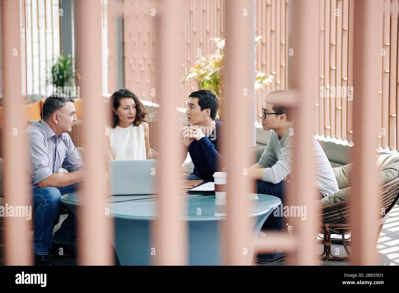 Serious business people gathered in meeting room to discuss plan of ...