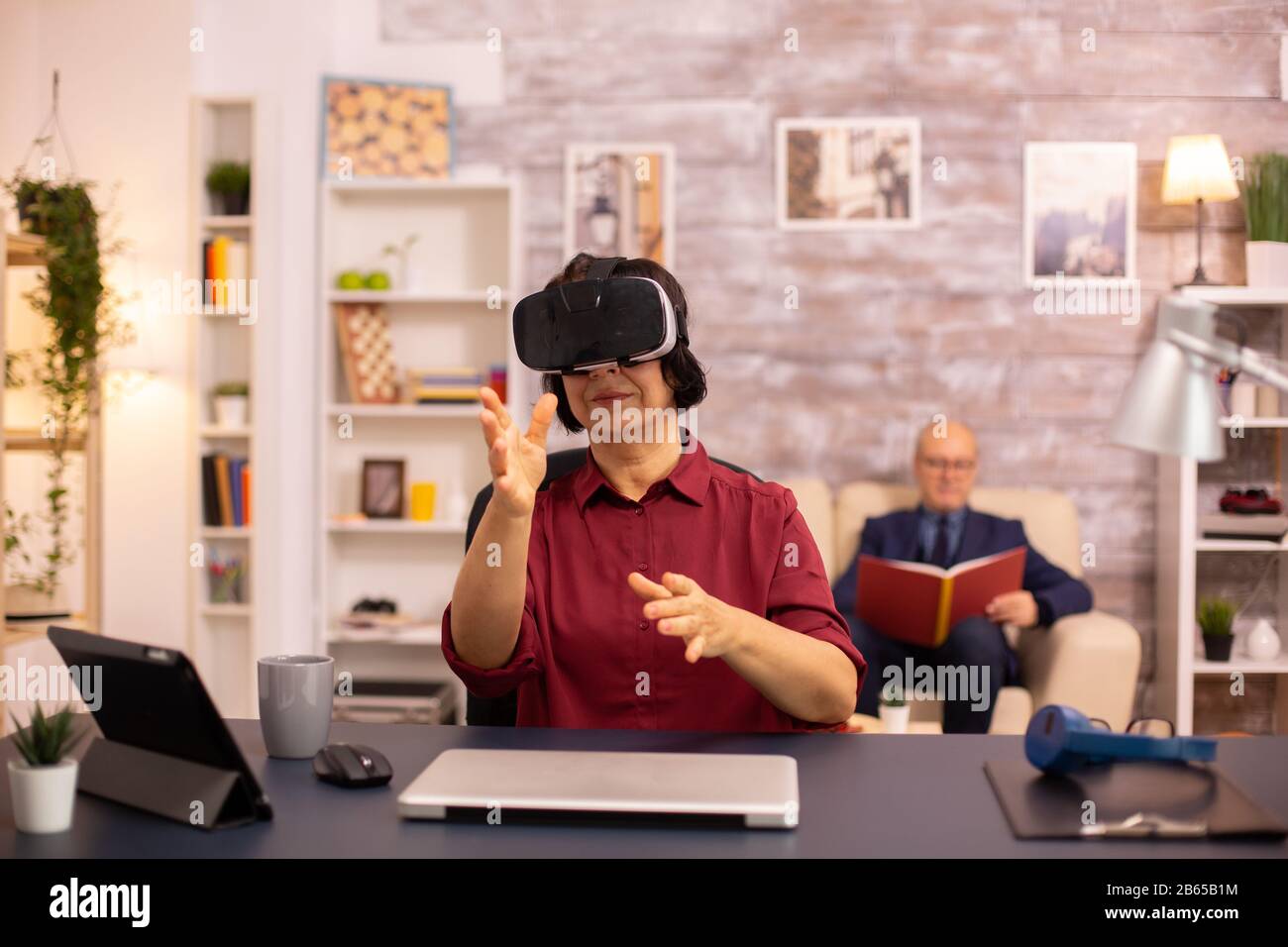 Old elderly woman using a VR virtual reality headset for the first time ...