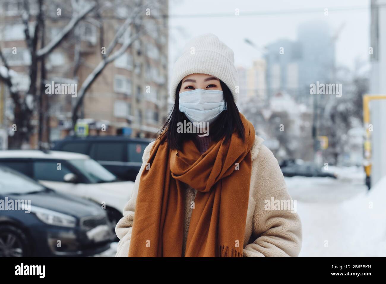 Passerby Asian girl in a protective medical mask outdoors. A woman on ...