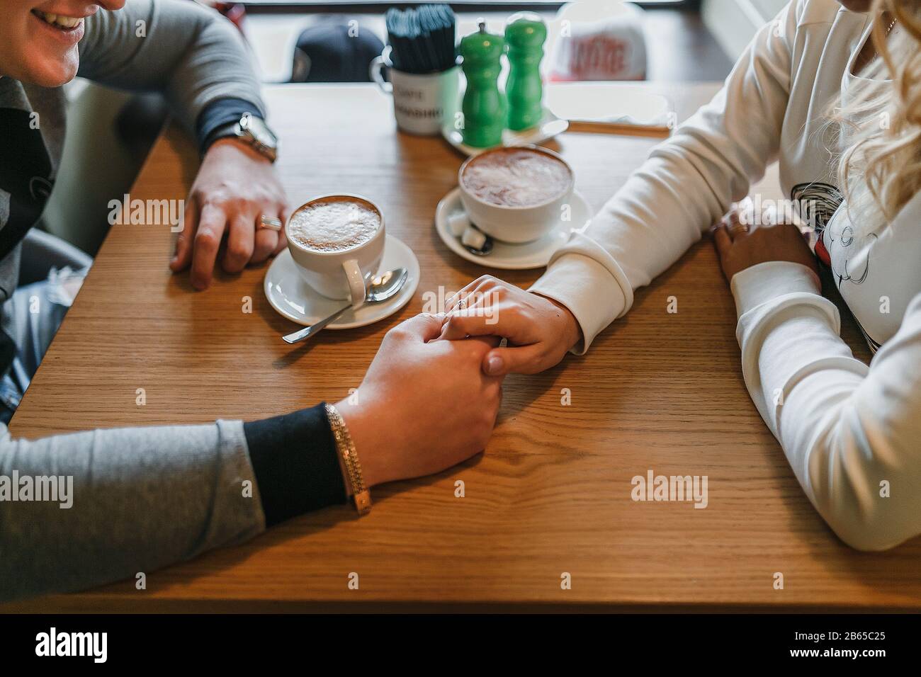 two hands of loving couple and cup of coffee in cute cafe Stock Photo ...