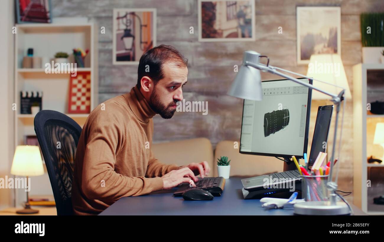 Young engineer working late at night in his home office to finish ...