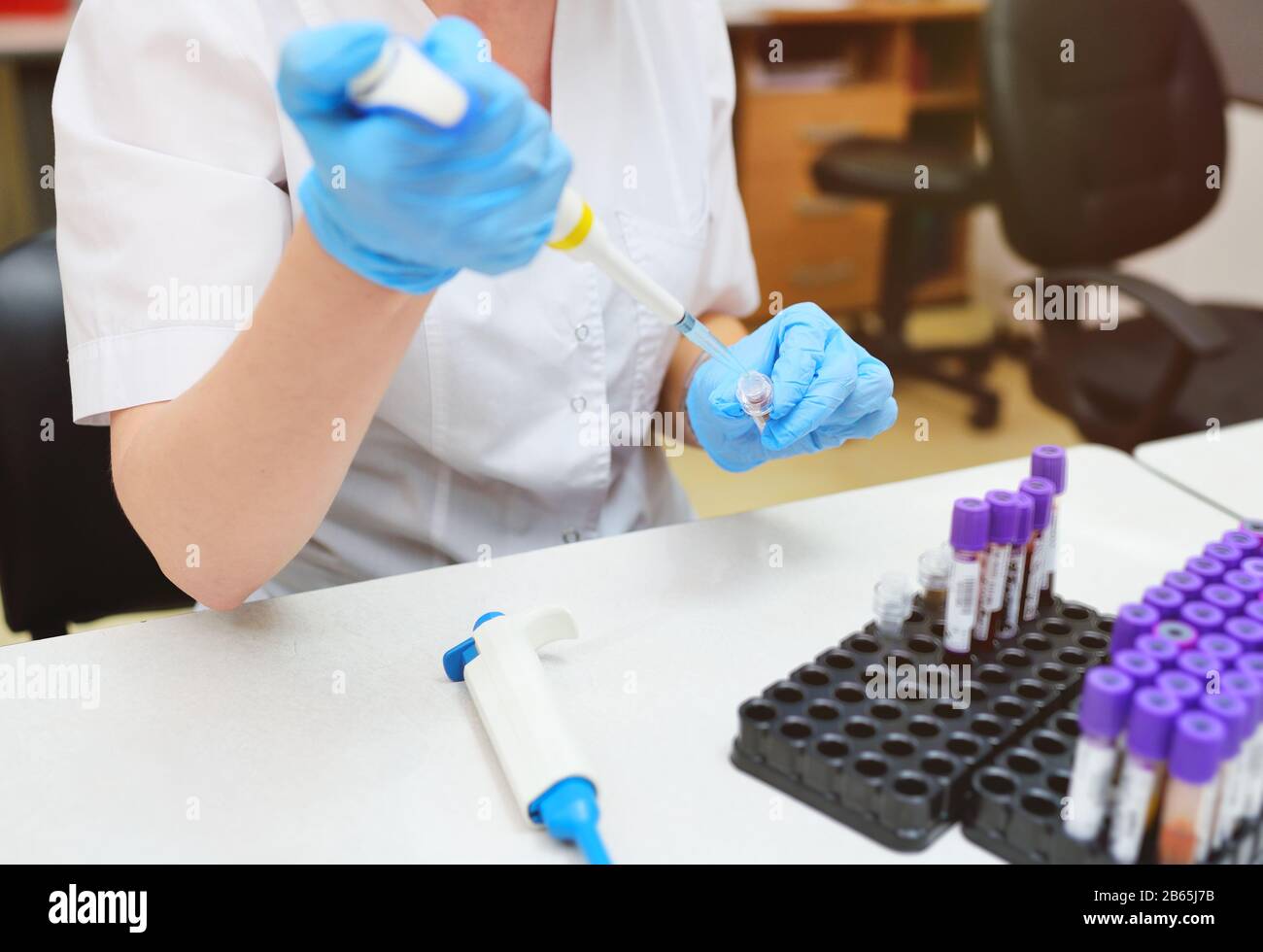 scientist in a medical laboratory with a dispenser in his hands is ...