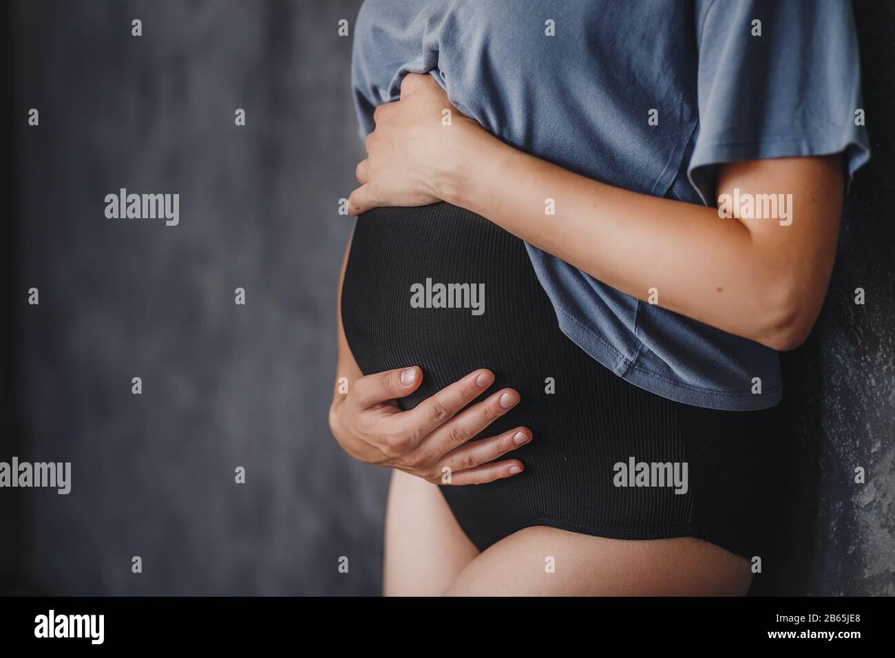 Close-up of unrecognizable pregnant belly with hands over tummy Stock ...