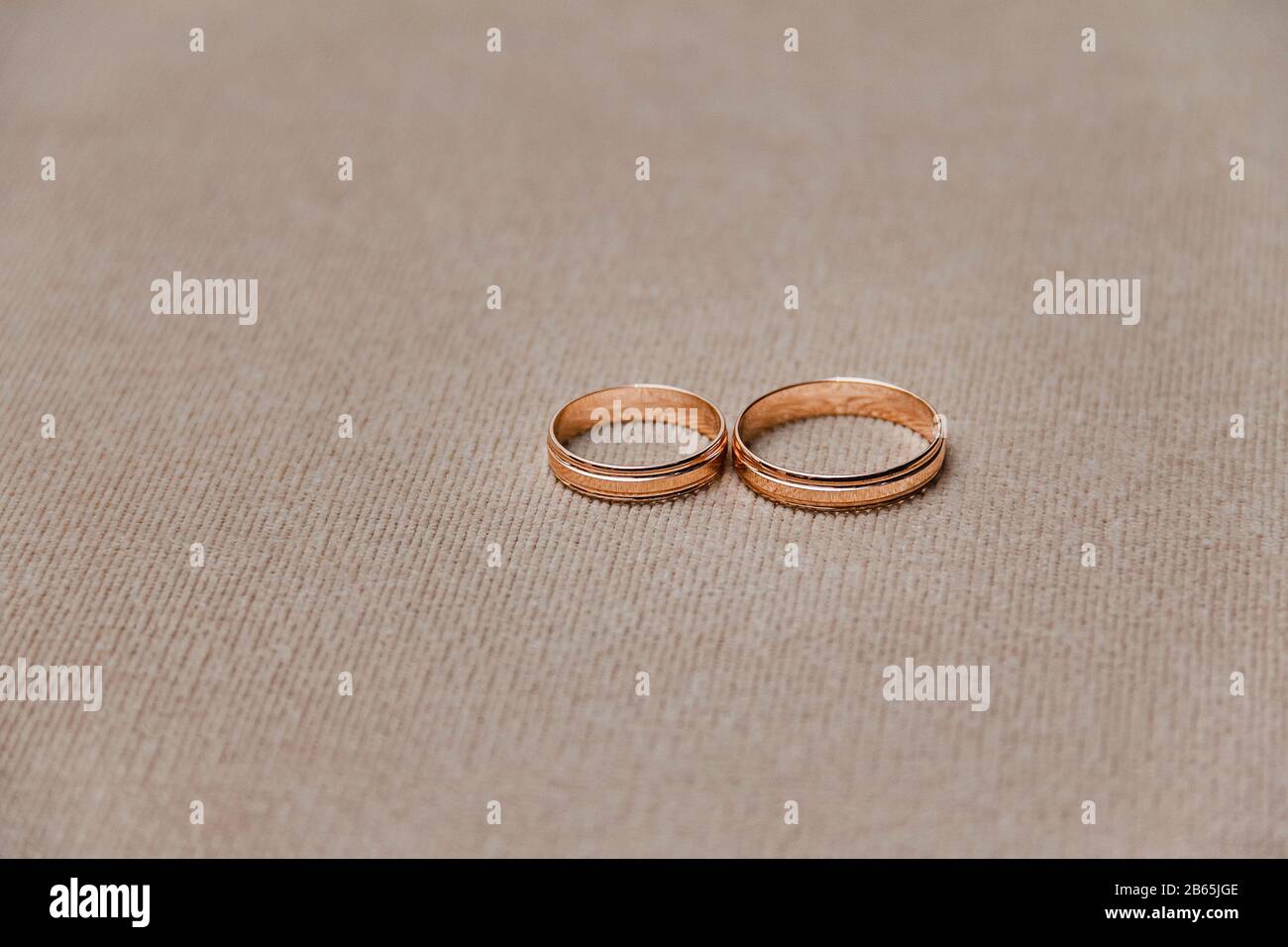 two wedding rings on sofa fabric Stock Photo - Alamy