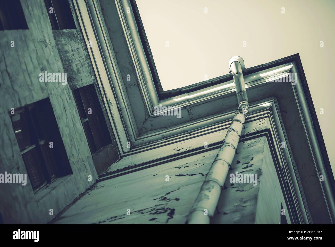 A sad, dark image of a corner of a dilapidated building with a ...