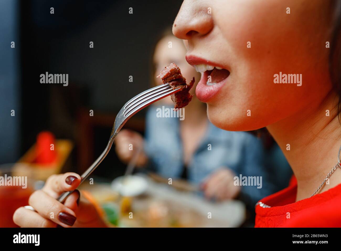 The woman is eating roasted meat Stock Photo - Alamy