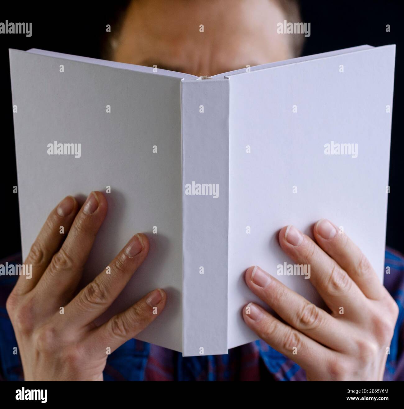 Men's hands hold a white book. Close-up Stock Photo - Alamy