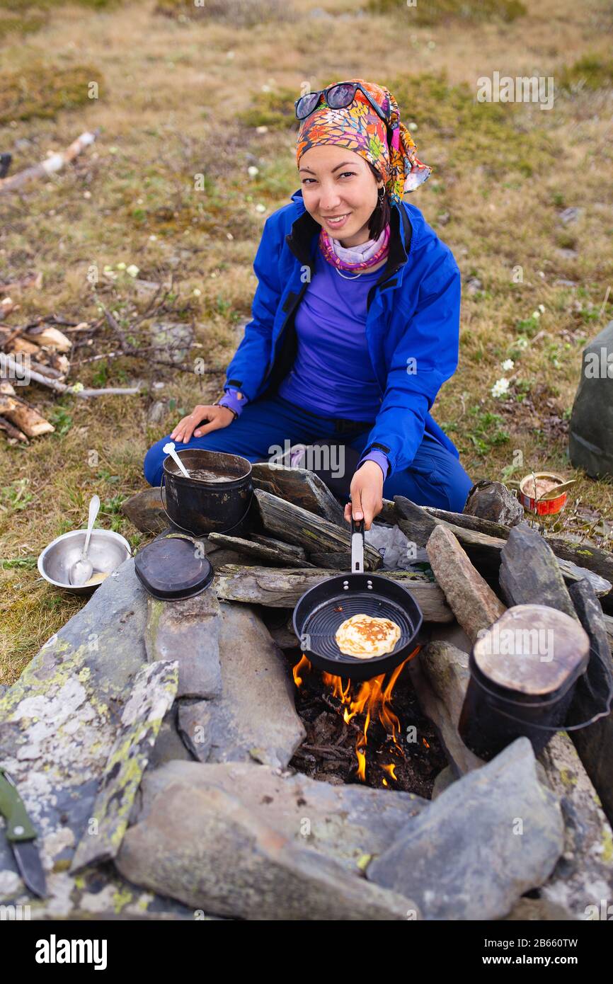 Cooking in the camp outdoors. Boiling pot on the campfire with pancakes ...