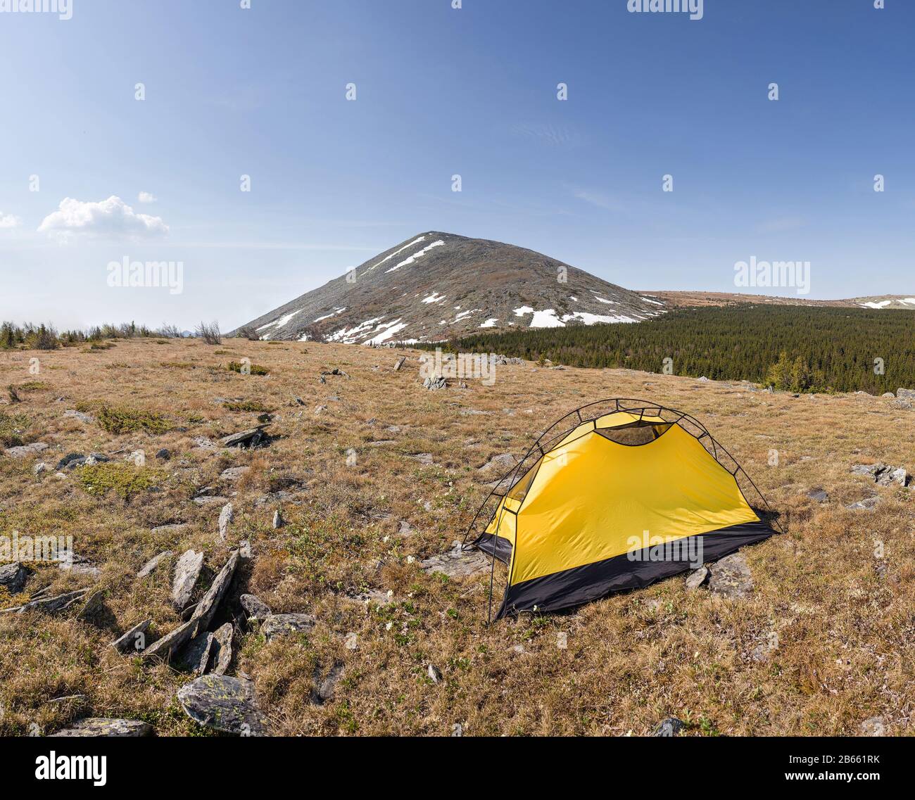 Yellow Camping tent in front of bald mountain hill Stock Photo - Alamy