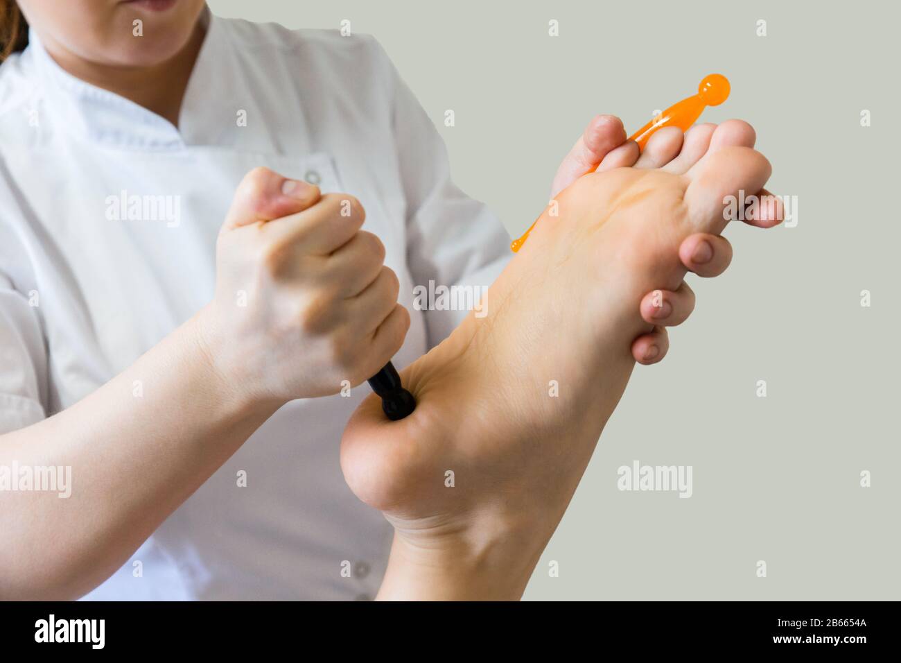 Acupressure of the feet with jade sticks in the massage parlor Stock ...