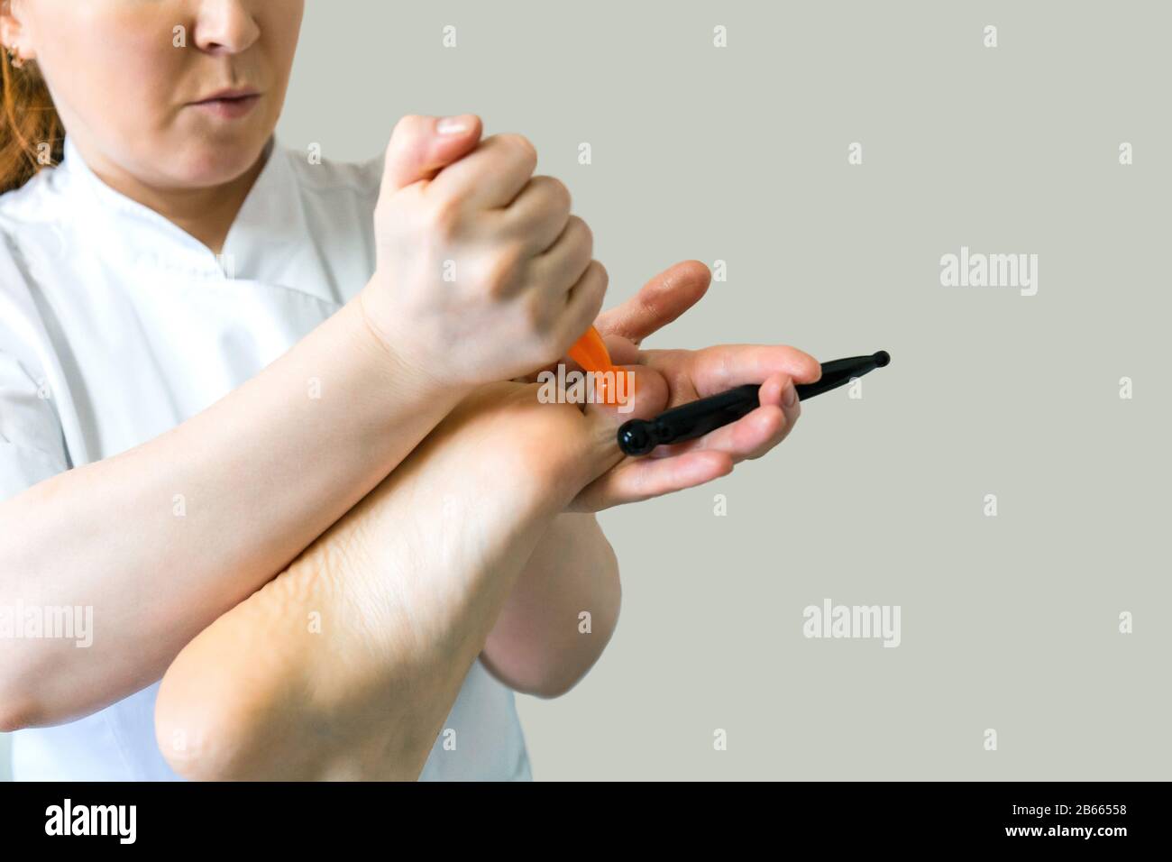 Acupressure of the feet with jade sticks in the massage parlor Stock ...