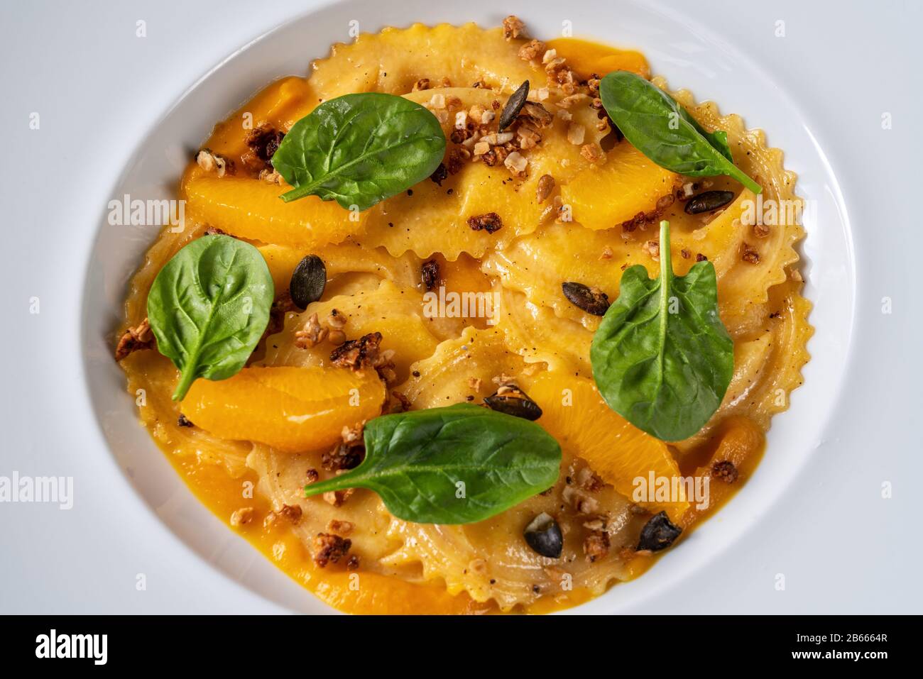 Italian dish, pasta ravioli with spinach and orange. From above, close ...