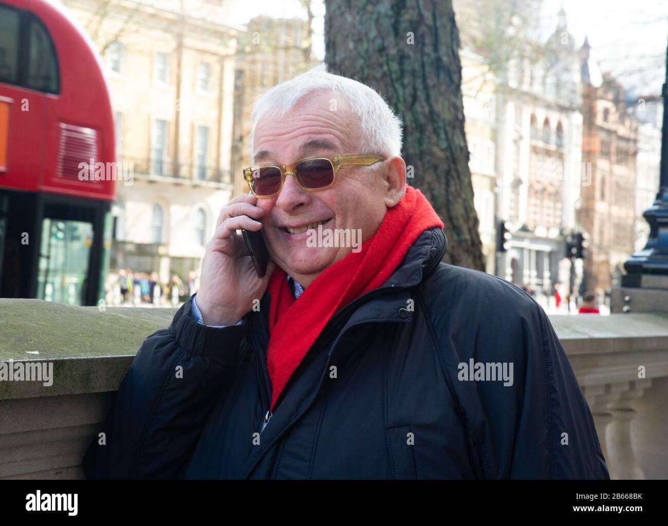 Actor Christopher Biggins, talks on the phone in Whitehall, London ...