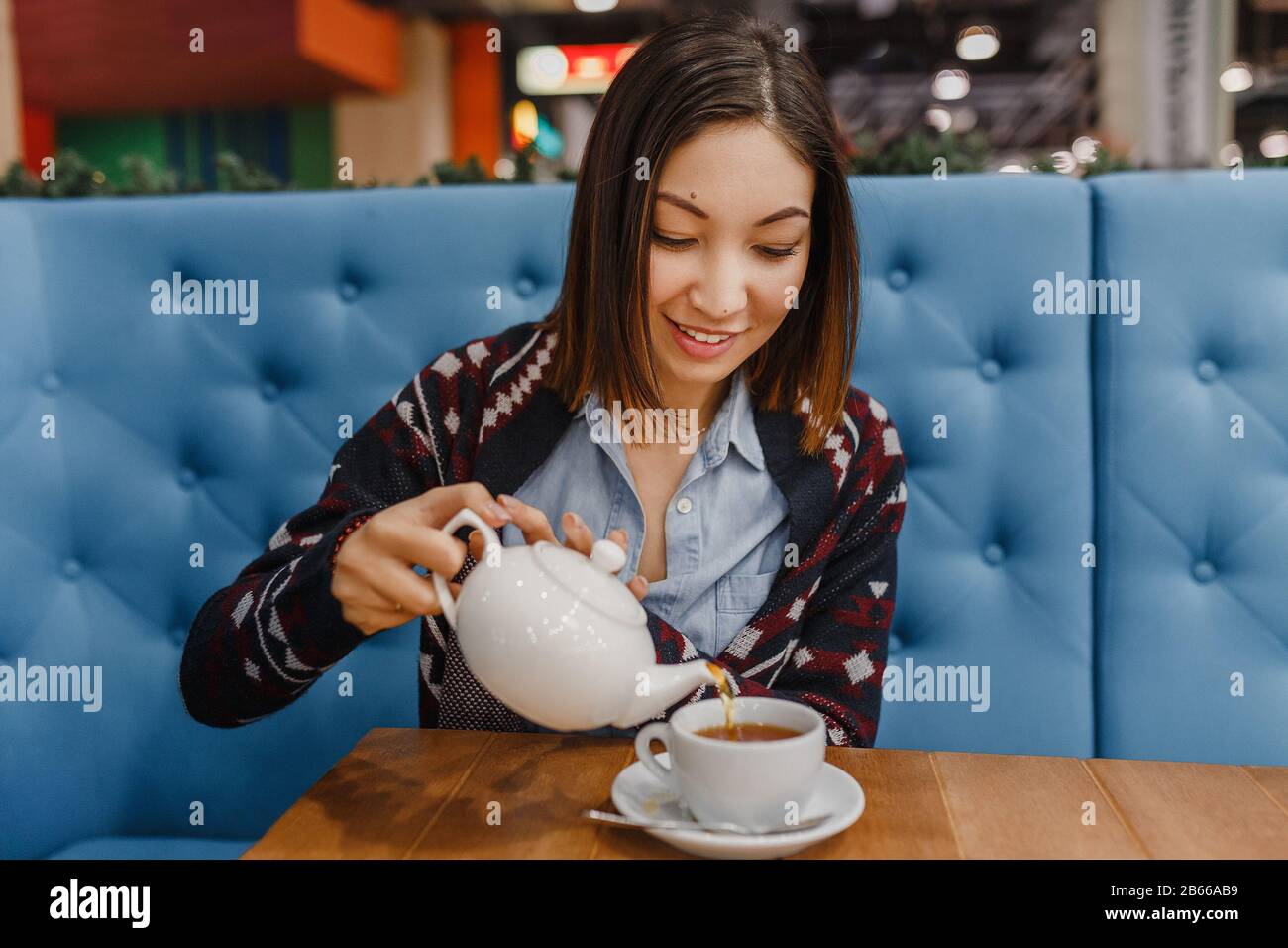 smiley woman pouring the cup of tea and smiling in the cafe Stock Photo ...