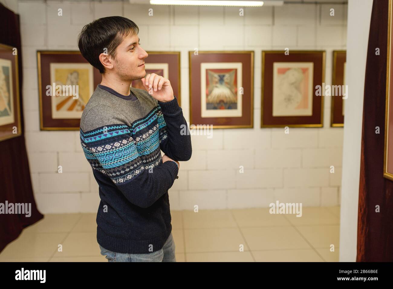 Young Man observing painting in art gallery Stock Photo - Alamy