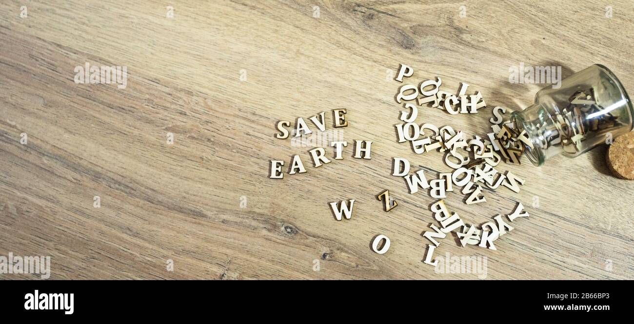 Wooden alphabet letter out of the bottle; save earth Stock Photo - Alamy