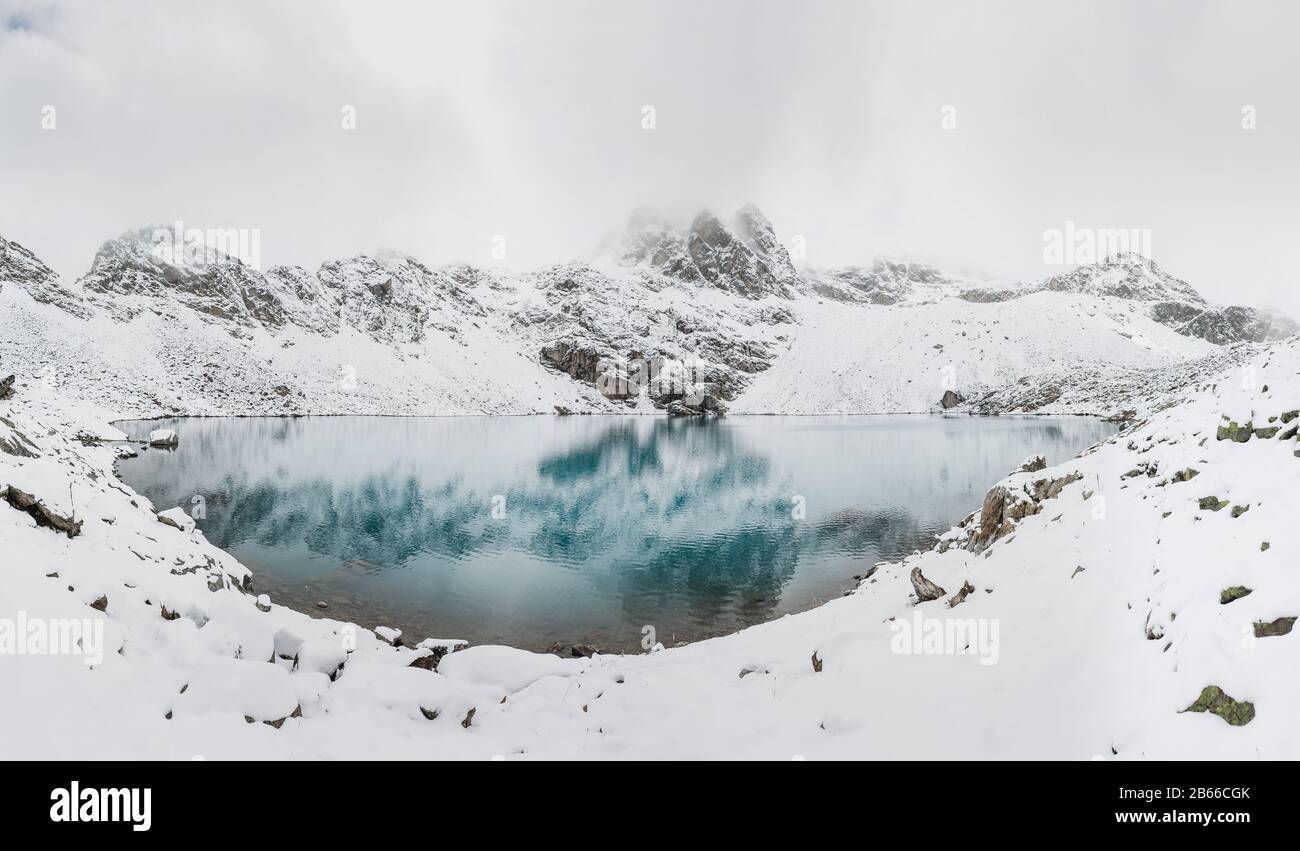 panorama of incredible blue lake surrounded by a chain of high snow ...