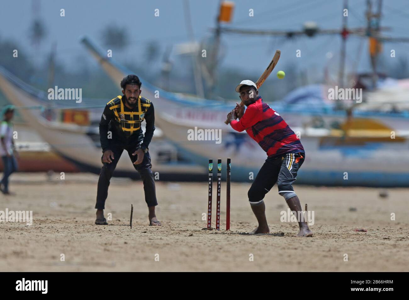 Sri Lankan cricket fans play a game of cricket on the beach at Galle ...