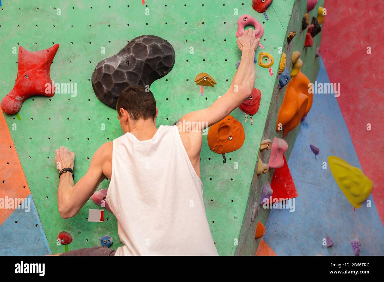 Strength and sporty male climbing on an indoor climbing wall Stock ...