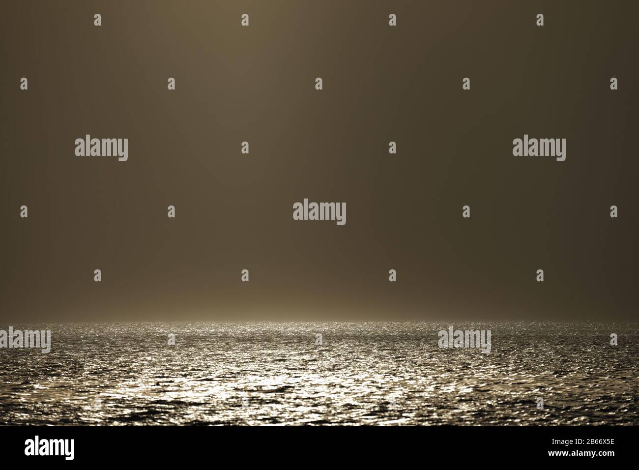 View of morning fog rising over water and lit by the sun creating a ...