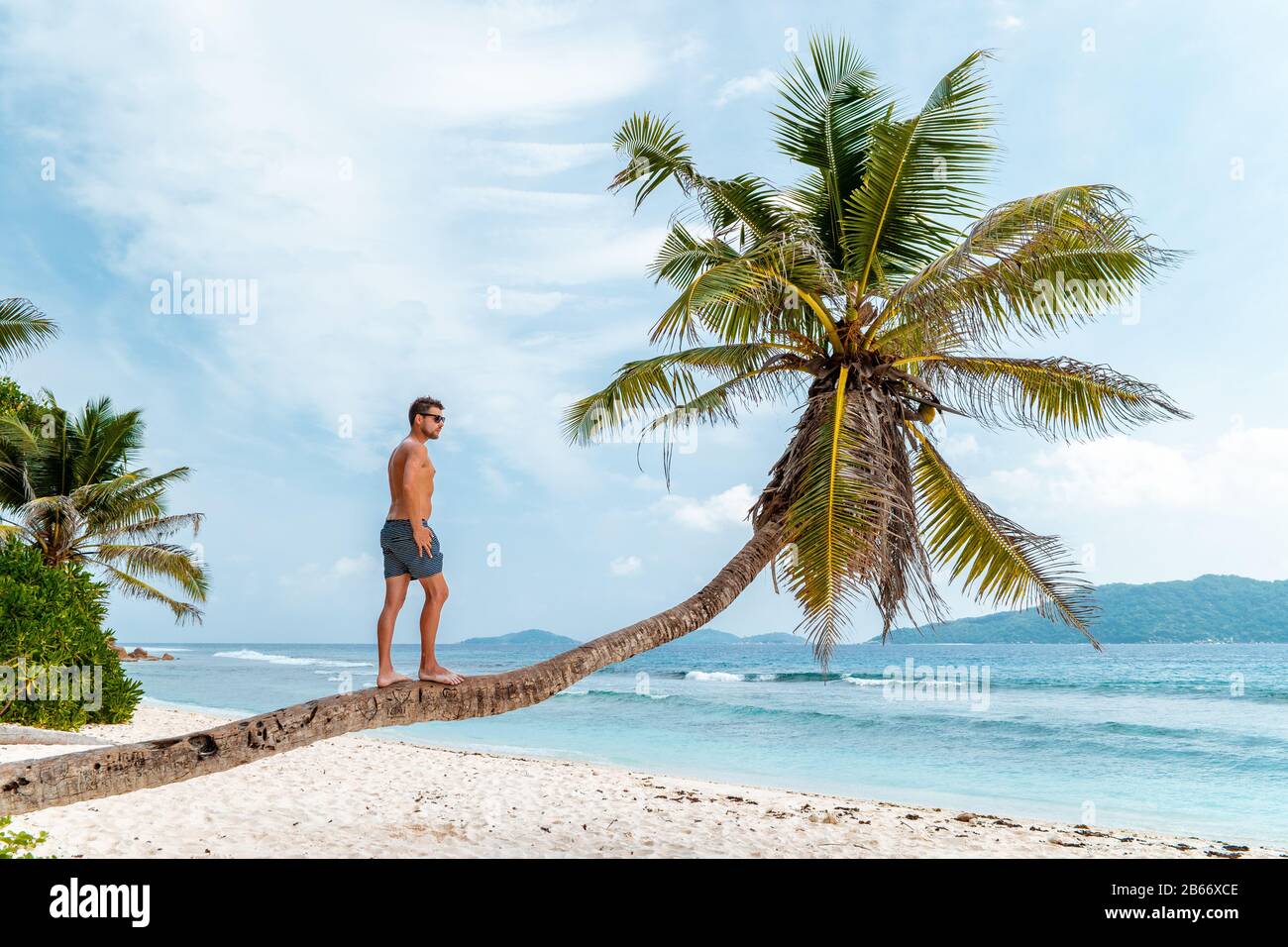 La Digue Seychelles,young man in casual clothes on the beach at Anse ...