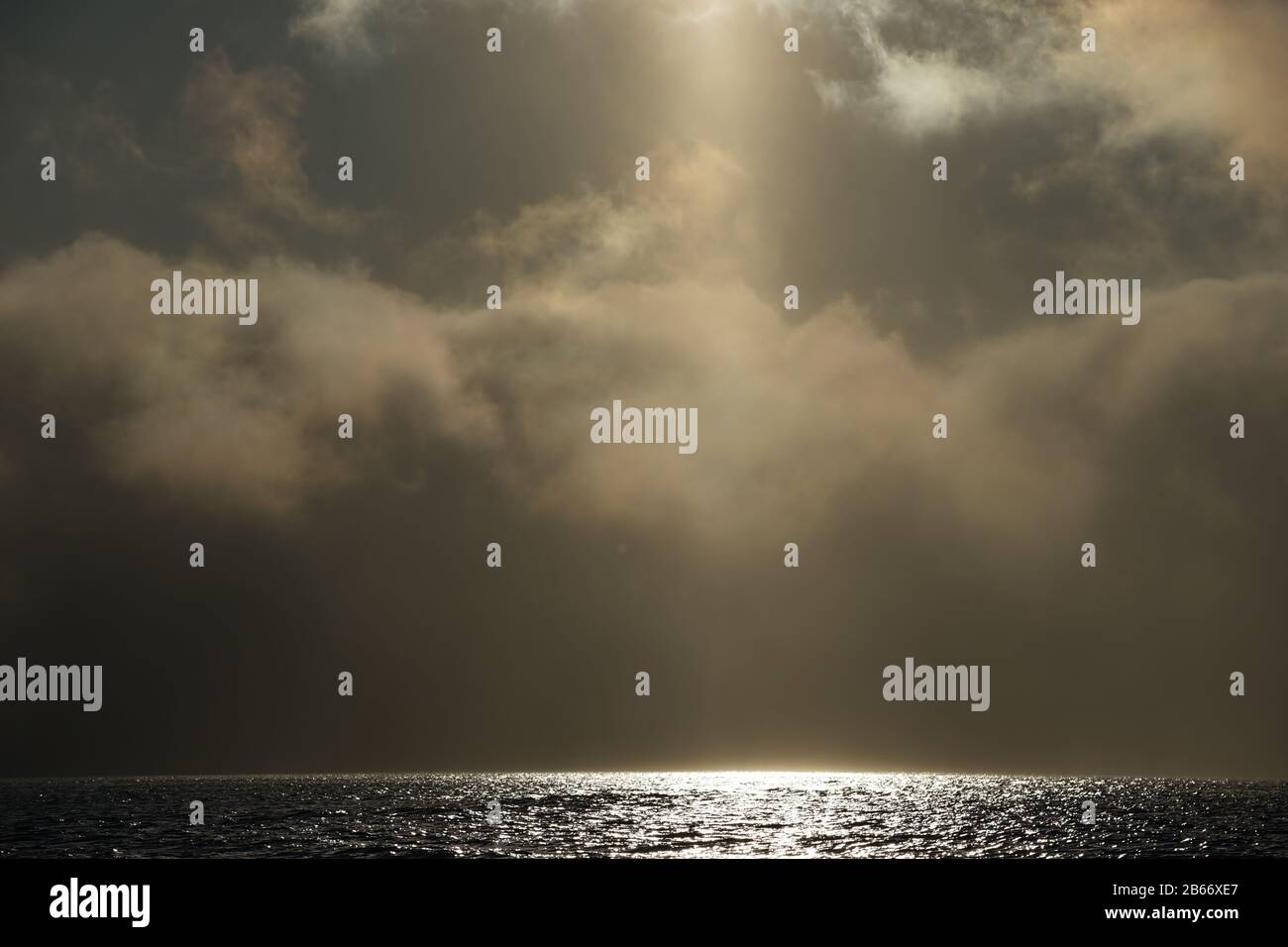 View of morning fog rising over water and lit by the sun creating a ...