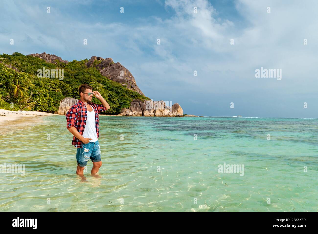 La Digue Seychelles,young man in casual clothes on the beach at Anse ...