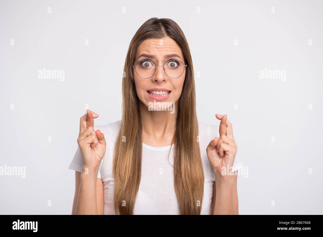 Photo of lady holding fingers crossed before final examination wear ...