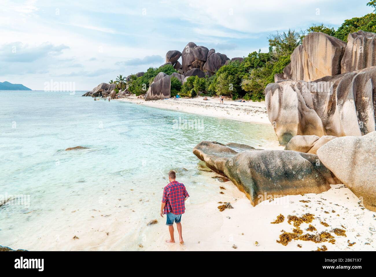 La Digue Seychelles,young man in casual clothes on the beach at Anse ...