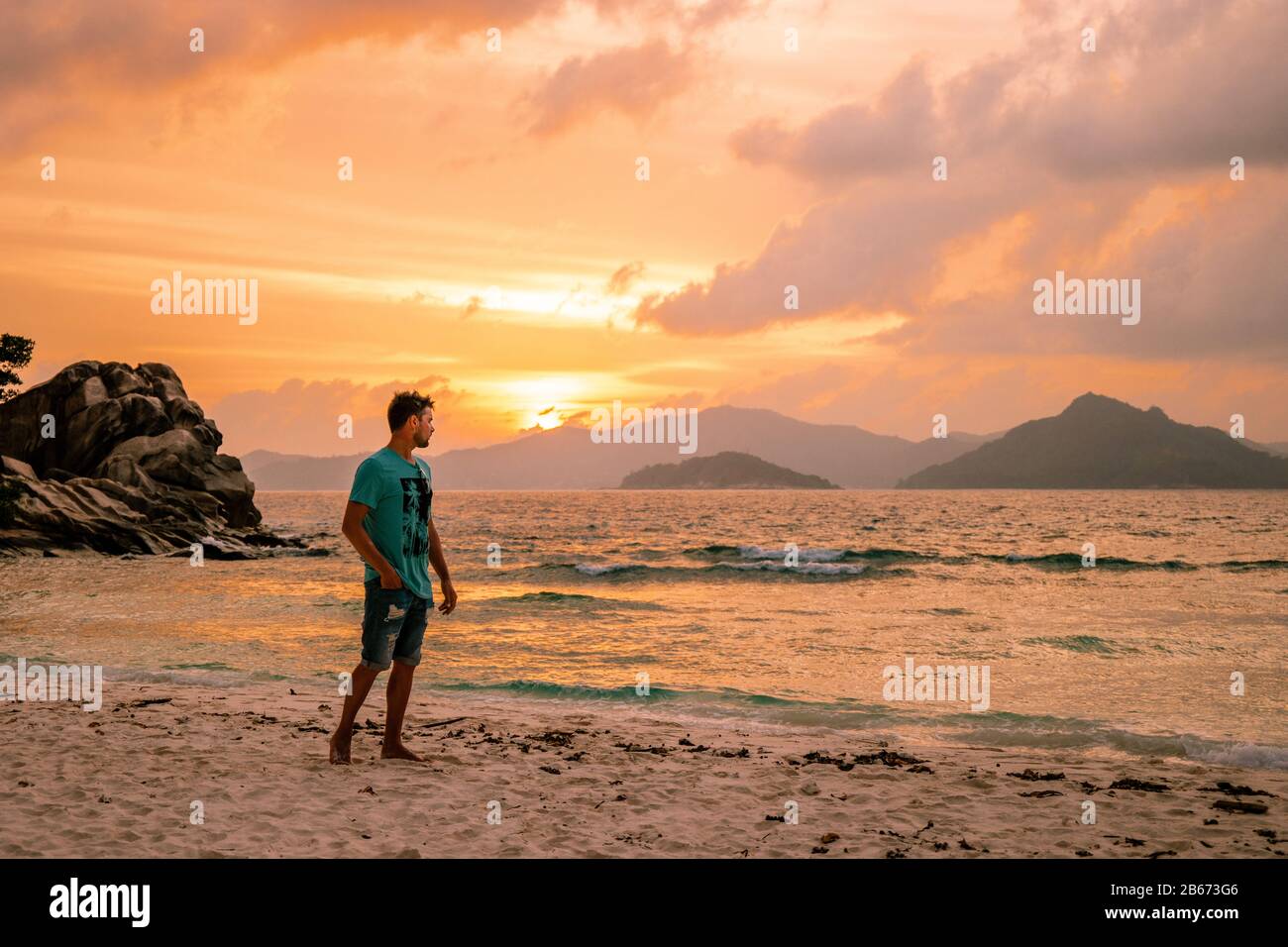 La Digue Seychelles,young man in casual clothes on the beach at Anse ...