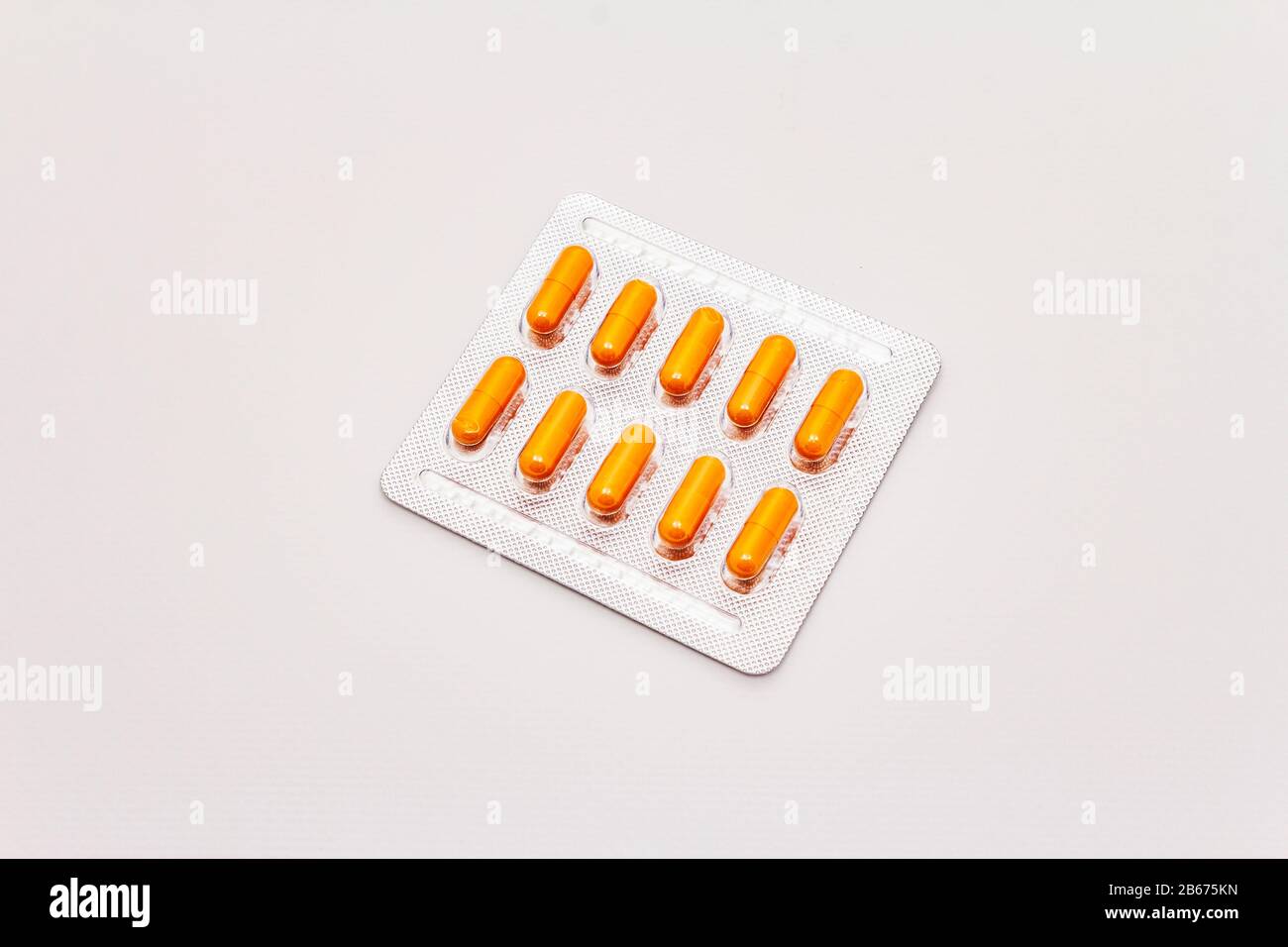 Pharmaceutical tablets, orange capsules in blister pack isolated on ...