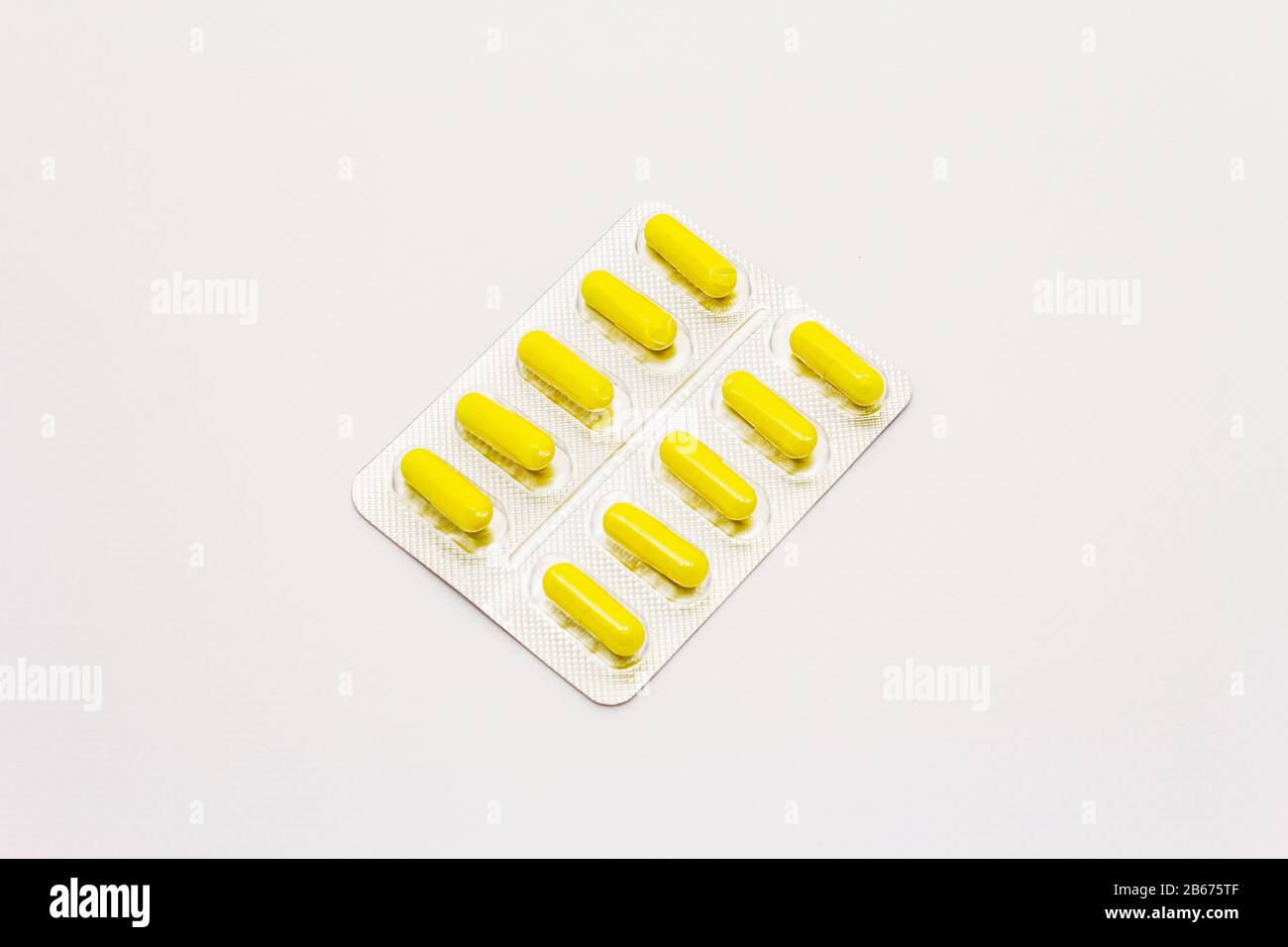 Pharmaceutical tablets, yellow capsules in blister pack isolated on ...