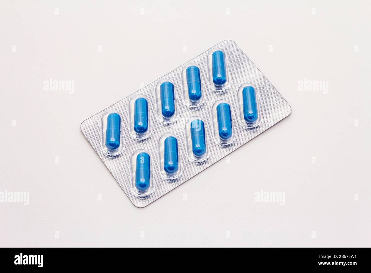 Pharmaceutical tablets, navy blue capsules in blister pack isolated on ...