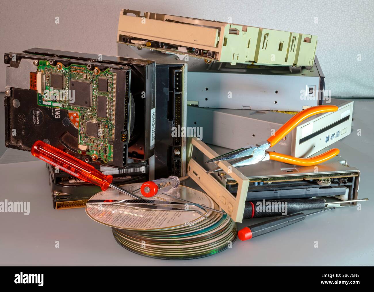 Stack of old SATA, ATA hard disk drives and driver cd disassembled ...