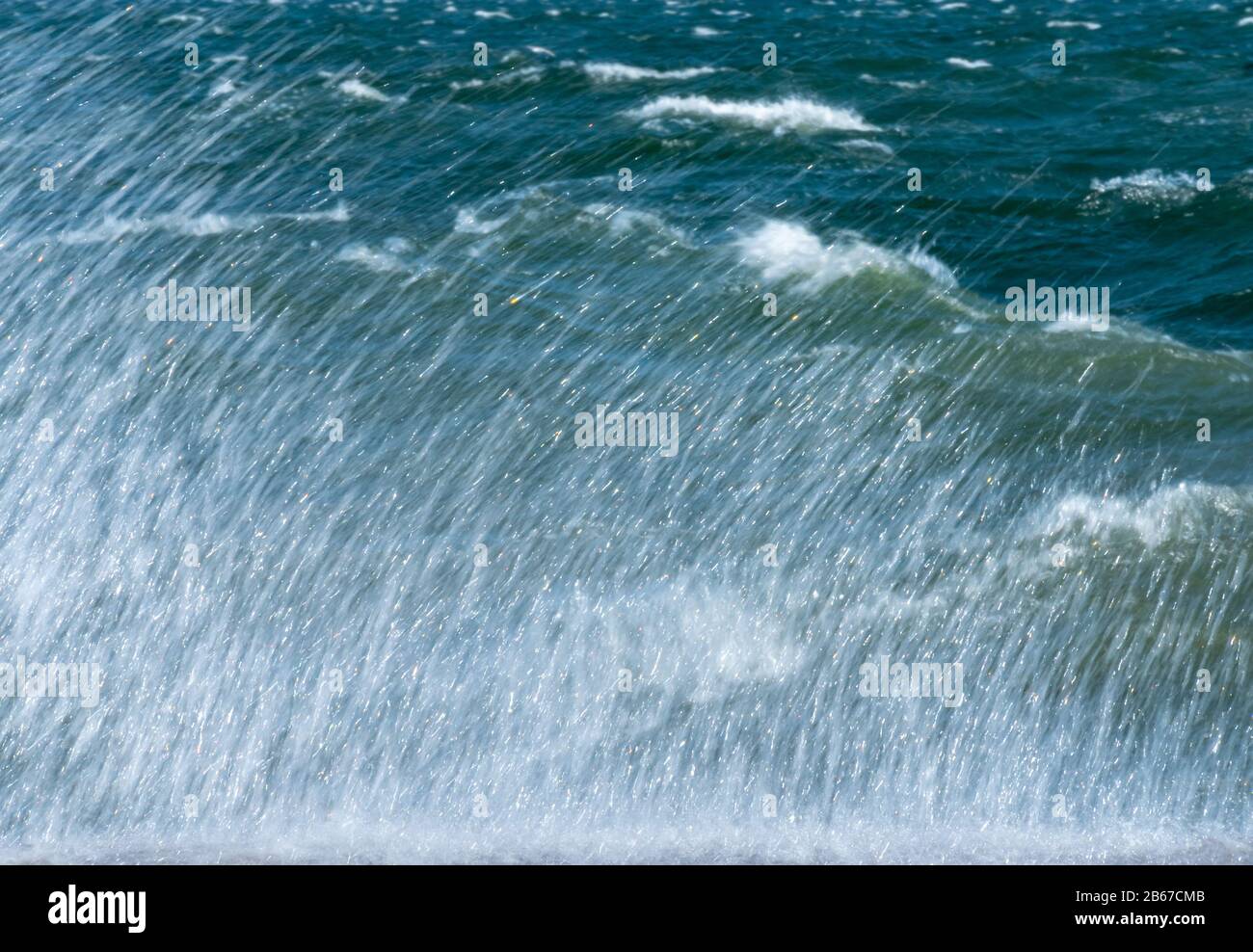 Waves hit the hard surface of concrete wall and splashing sea water ...