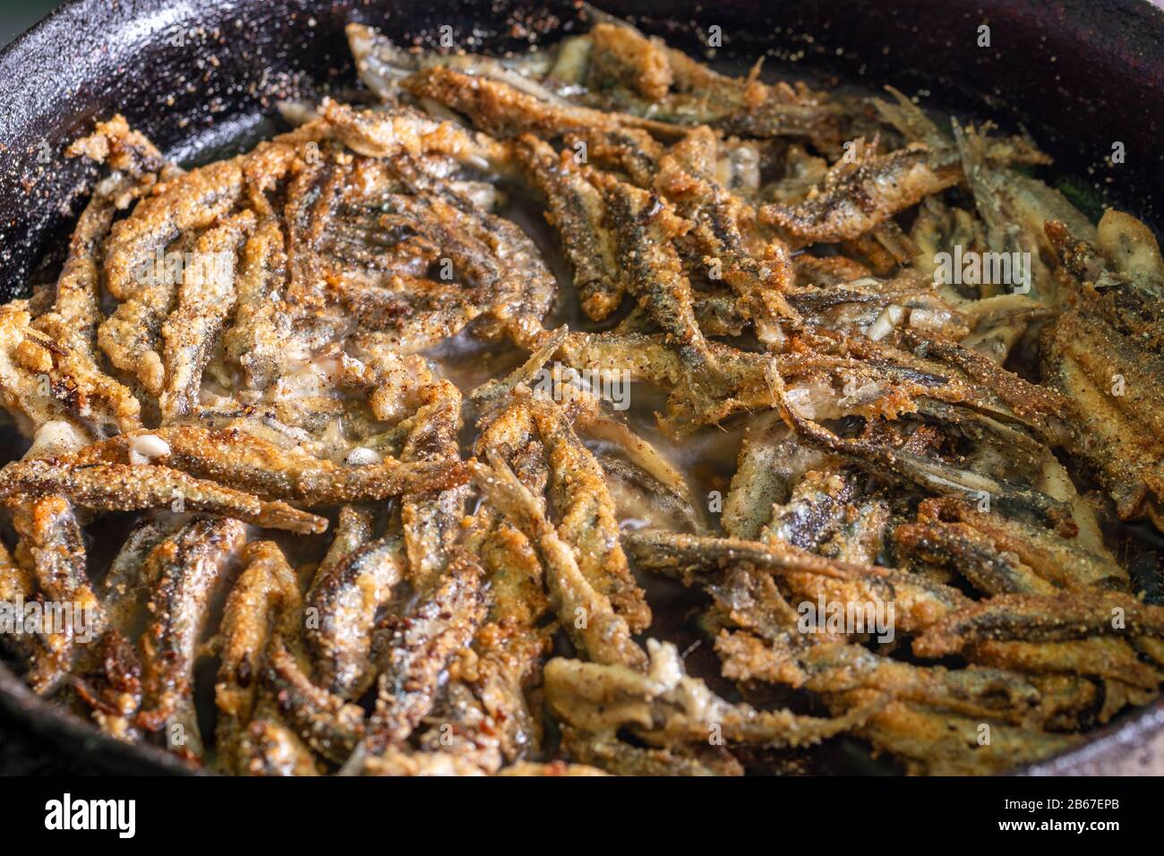 fried fish capelin on black frying pan Stock Photo - Alamy