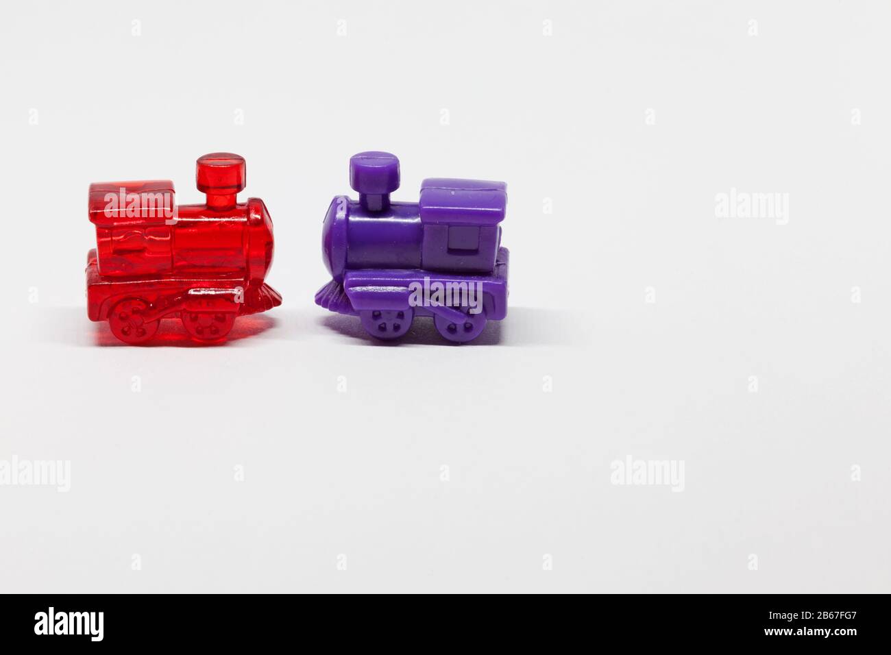 two plastic toy trains, one red and one purple Stock Photo - Alamy