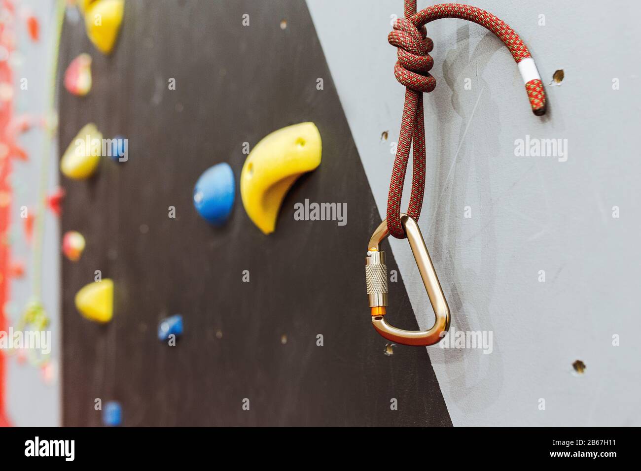 Image of a carabiner hook with a climbing rope at indoors artificial ...